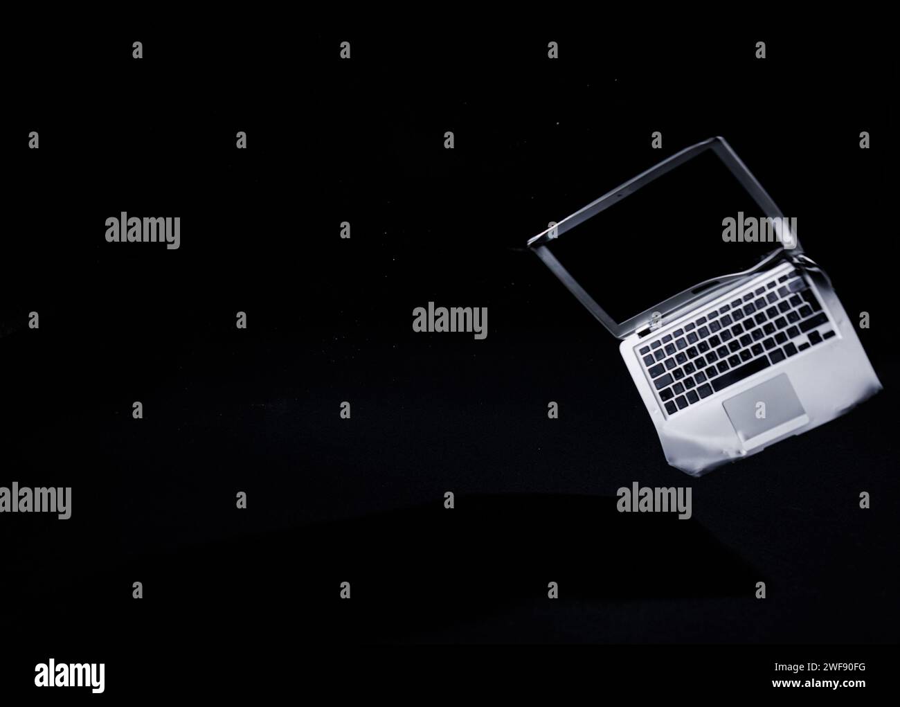 Device crashing on a hard black floor, a smashed and broken laptop with ...