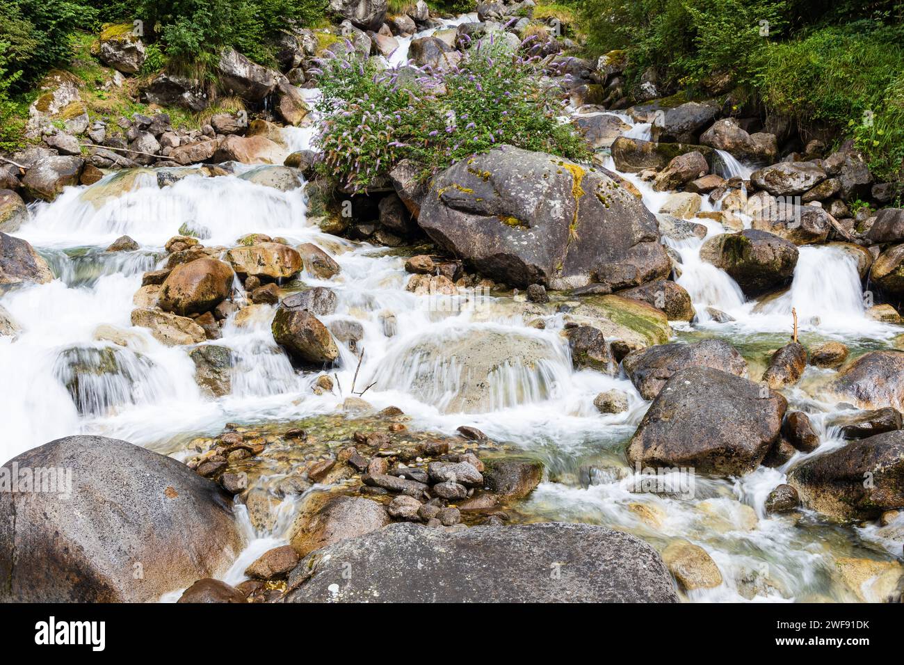 A stream of water flowing through rocks. Fragment of the Lutour ...