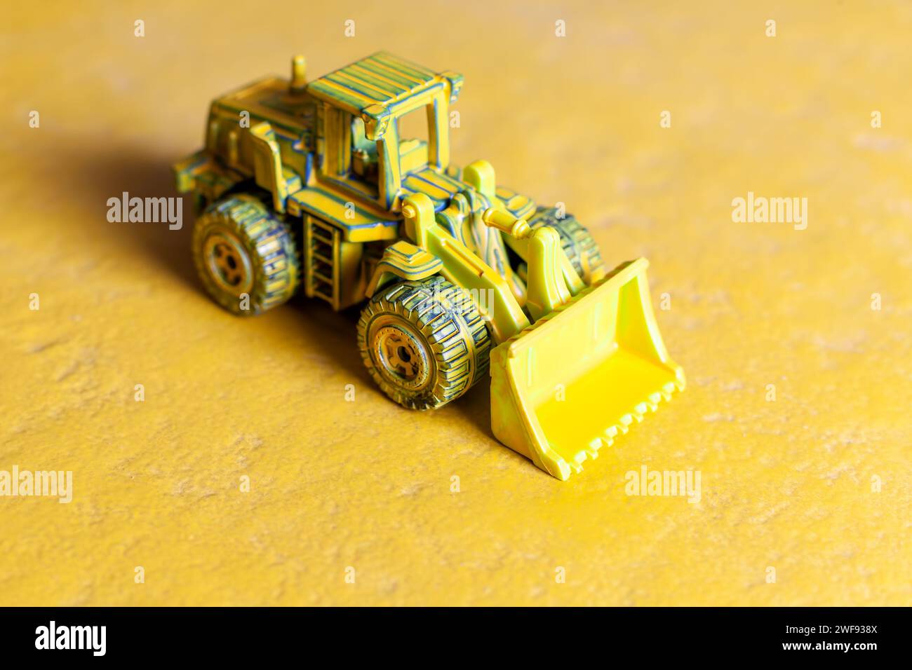 yellow toy bulldozer on yellow background Stock Photo - Alamy