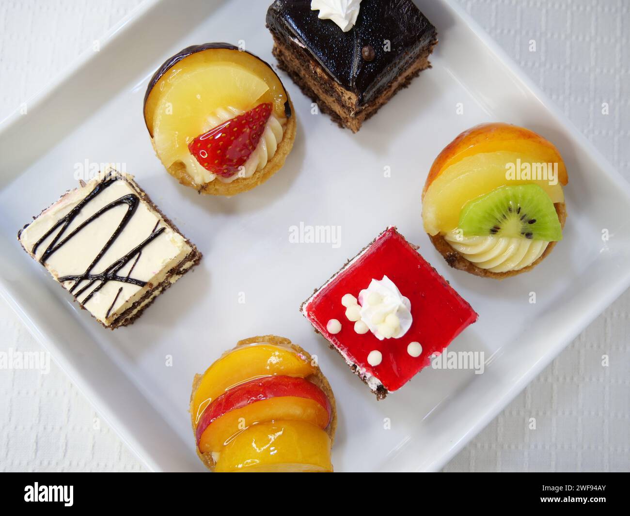 Assorted fruit desserts topped with creamy goodness and sliced kiwi ...