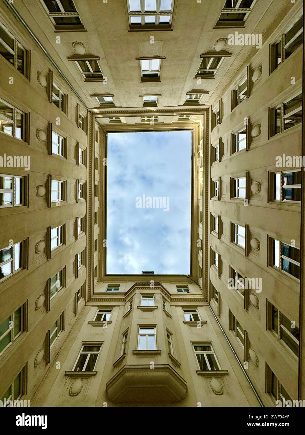 A tall apartment building with a blue sky backdrop Stock Photo - Alamy