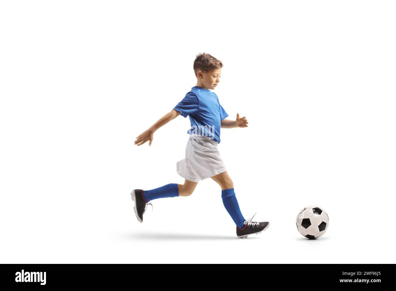 Boy in a blue and white football kit running fast with and leading a ...