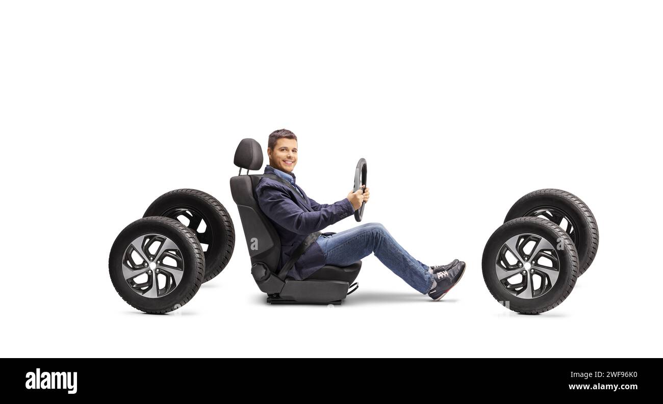 Full length profile shot of a man in a car seat driving on four tires ...