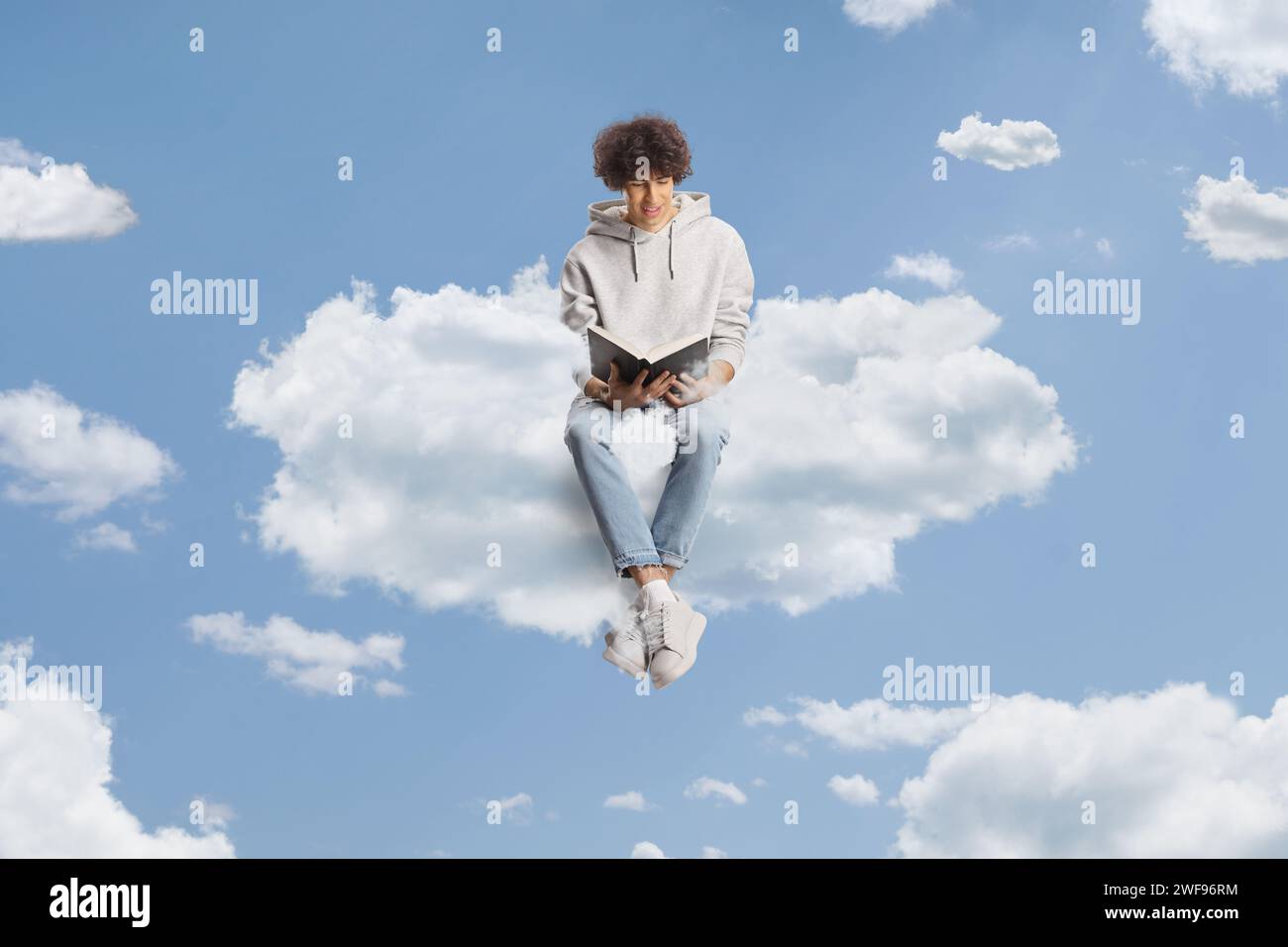 Casual young man sitting on a cloud and reading a book in the sky Stock ...