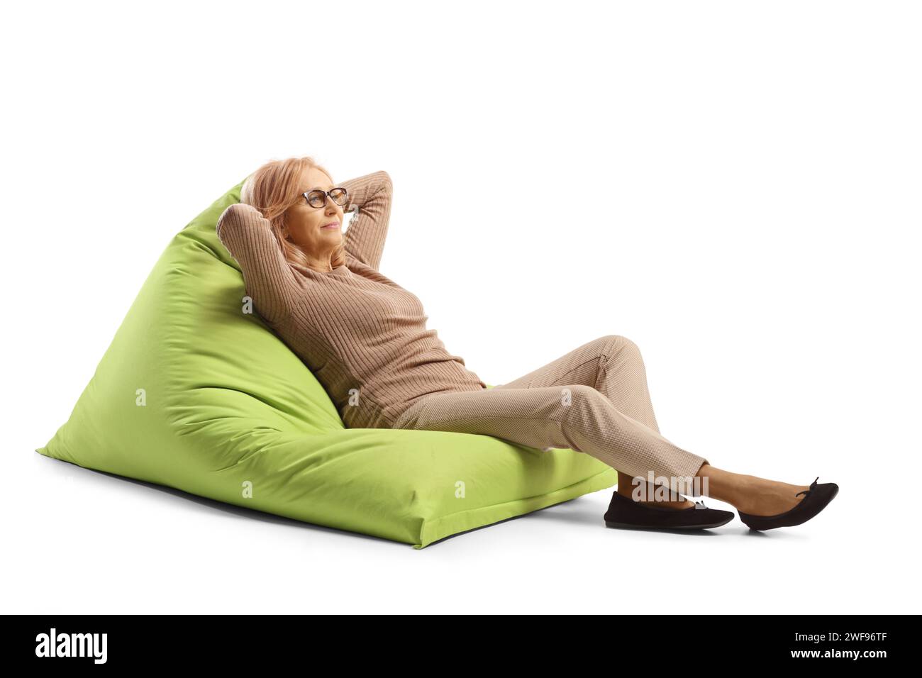 Middle aged woman resting on a green bean bag armchair isolated on ...