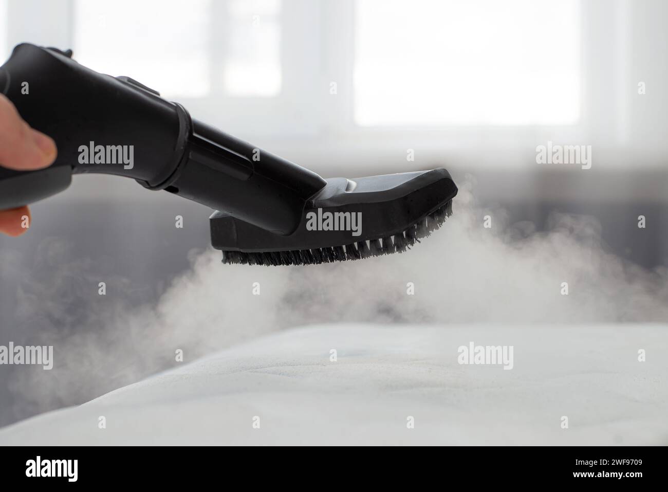 Cleaning and disinfection of the mattress in the bedroom with hot steam ...