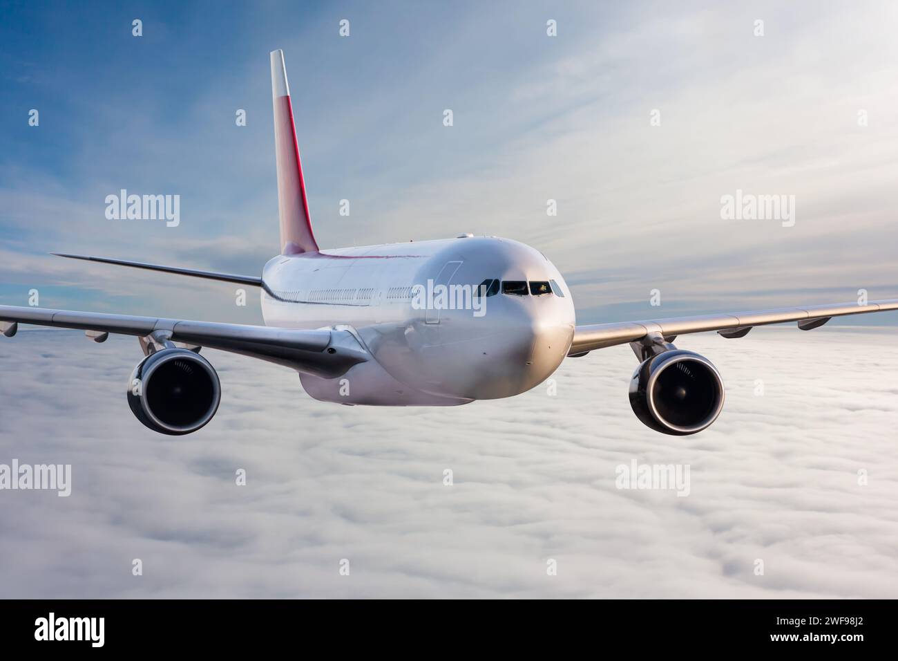 Wide body passenger airliner flying in the air above the clouds Stock ...