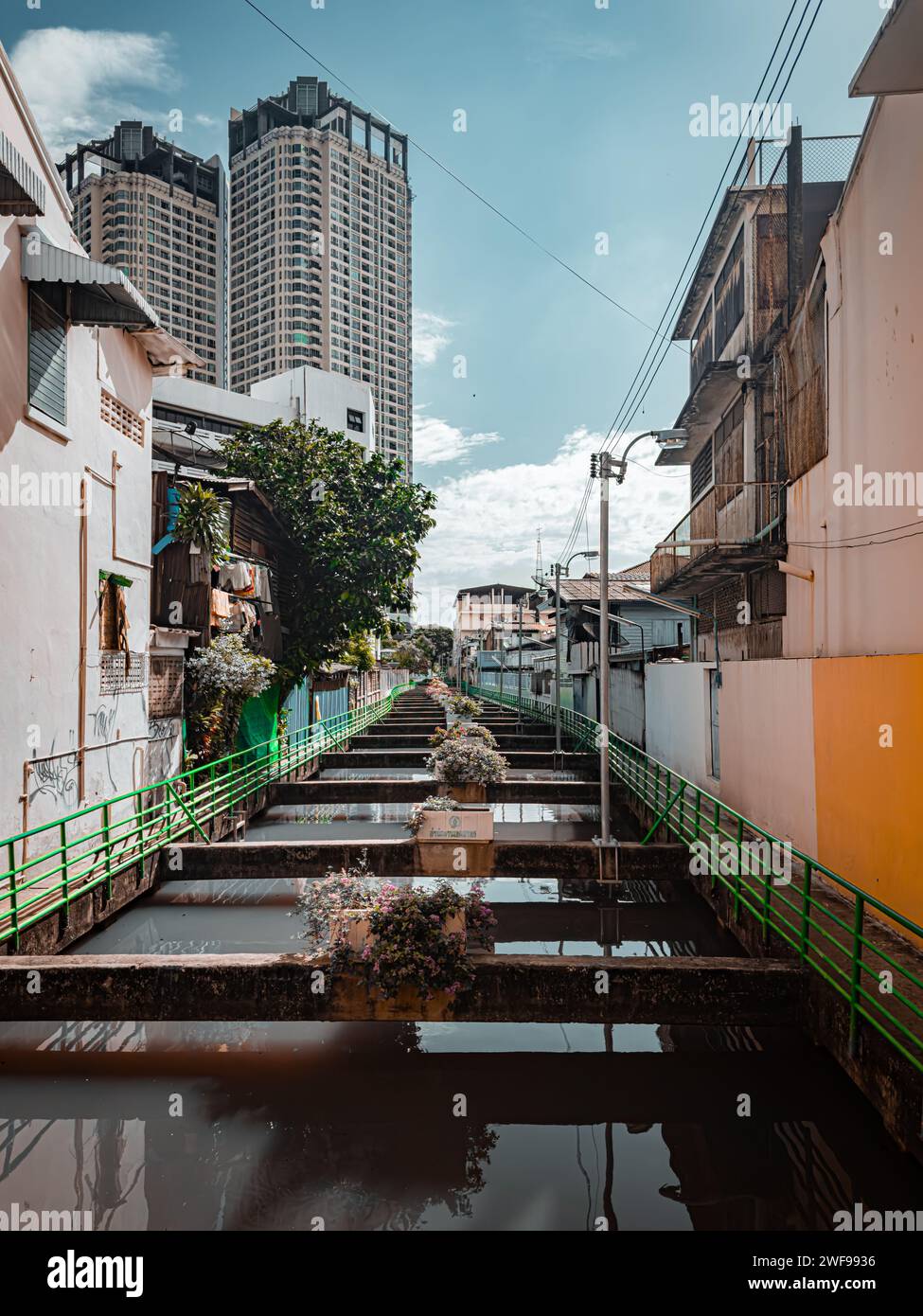 This image captures a quiet urban canal with clear skies above ...
