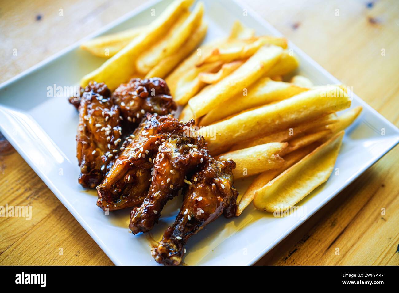 Baked chicken wings and legs with French fries on a plate Stock Photo ...