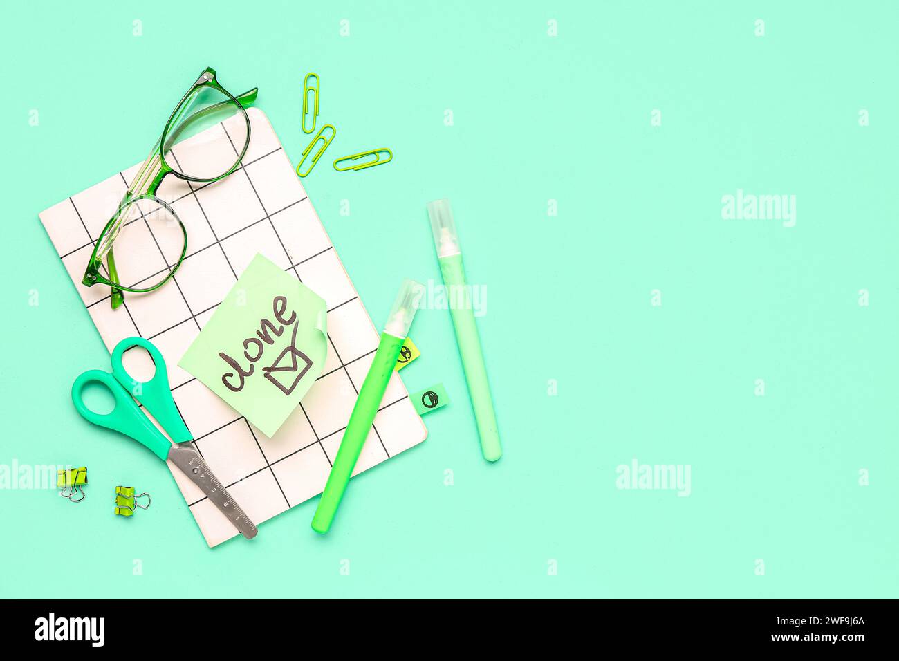 Sticky note with word DONE, eyeglasses and stationery on green ...