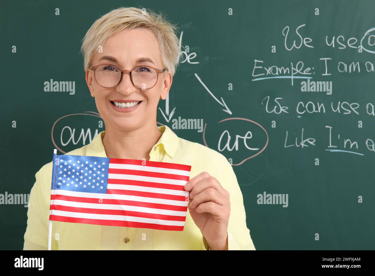 Female English teacher with USA flag in classroom, closeup Stock Photo ...