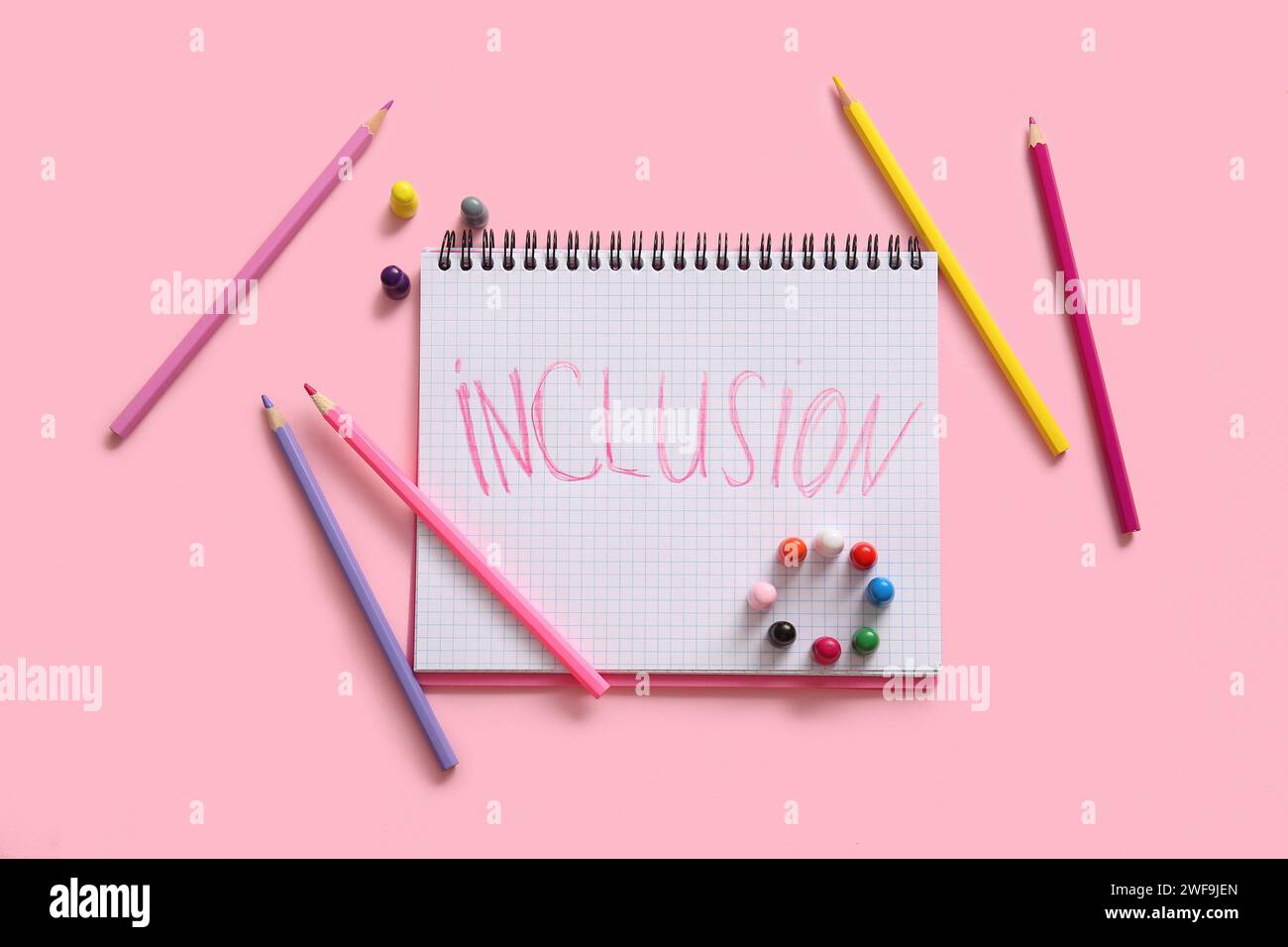 Notebook with word INCLUSION, pencils and pawns on pink background ...