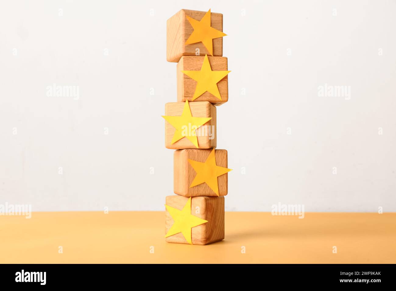 Wooden cubes with five stars rating on table against white background ...