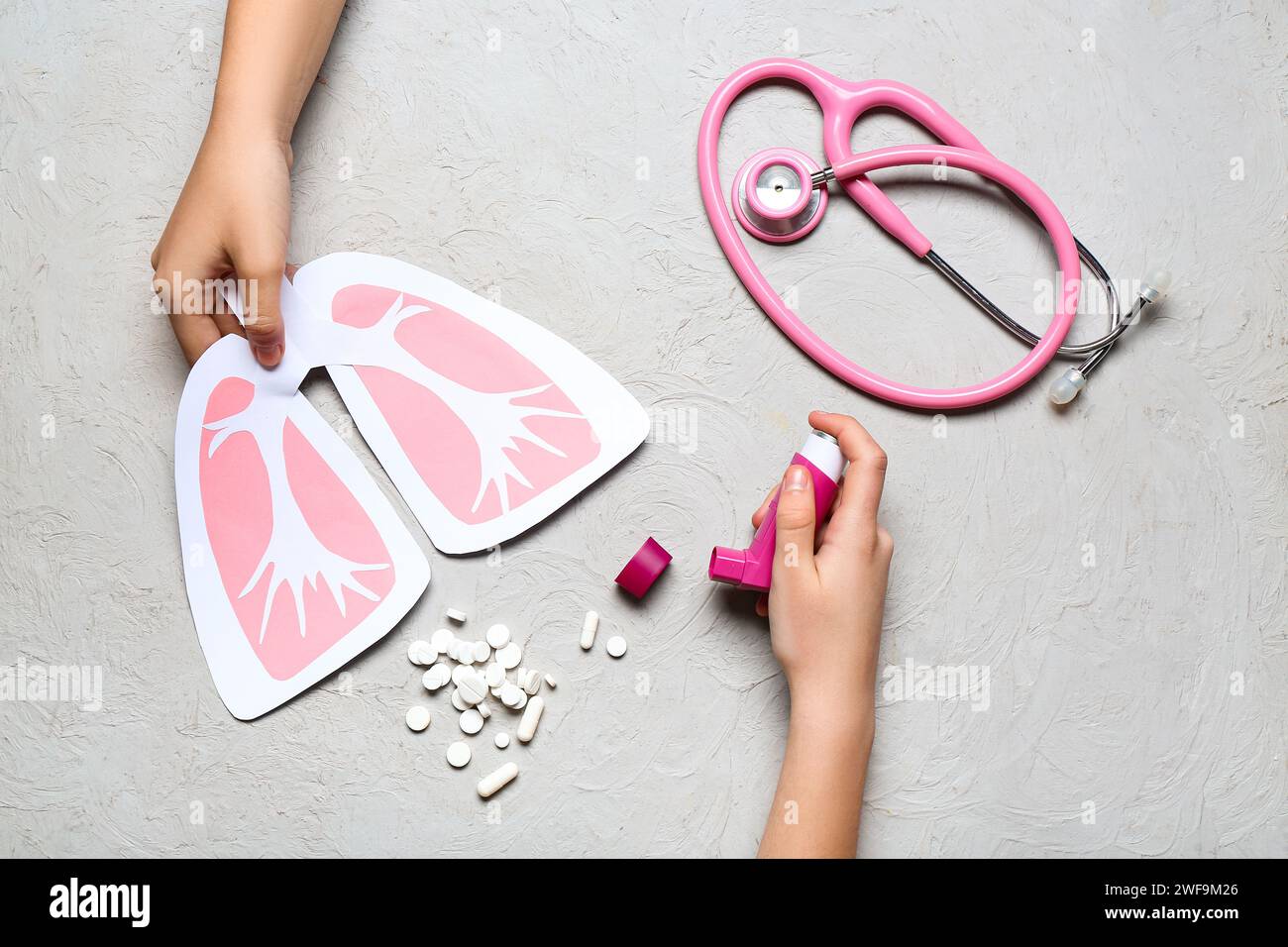Female hands with paper lungs, asthma inhaler, pills and stethoscope on ...