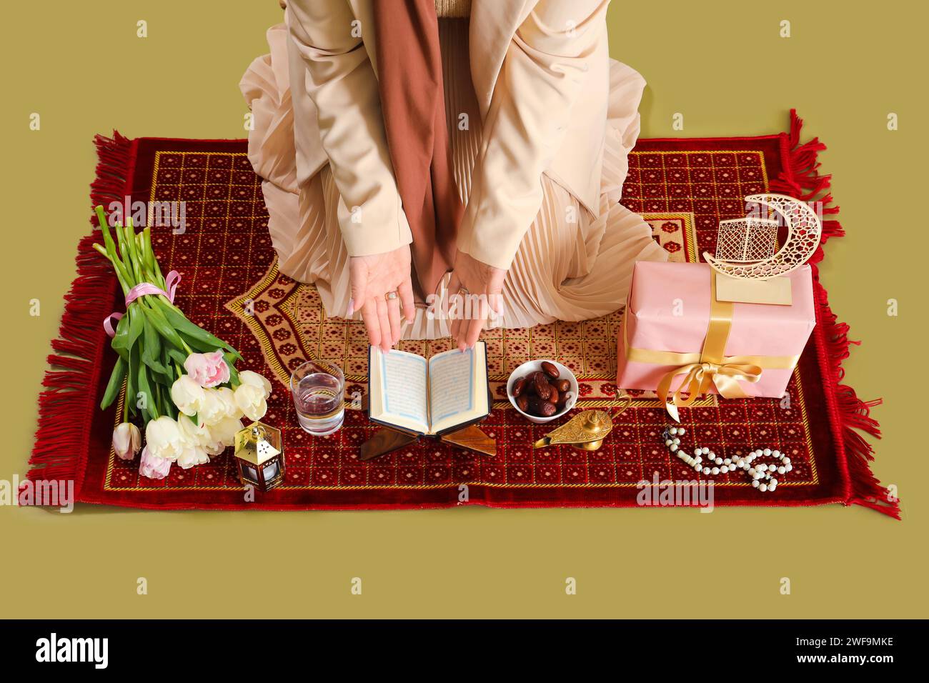 Mature Muslim woman praying on mat against green background. Ramadan ...