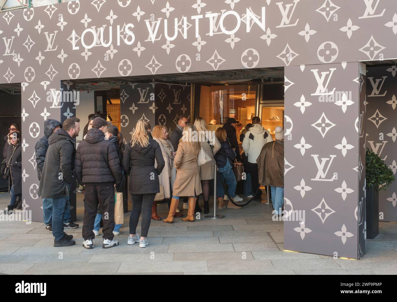 Queue of people waiting in front of the Cologne branch of the Parisian ...