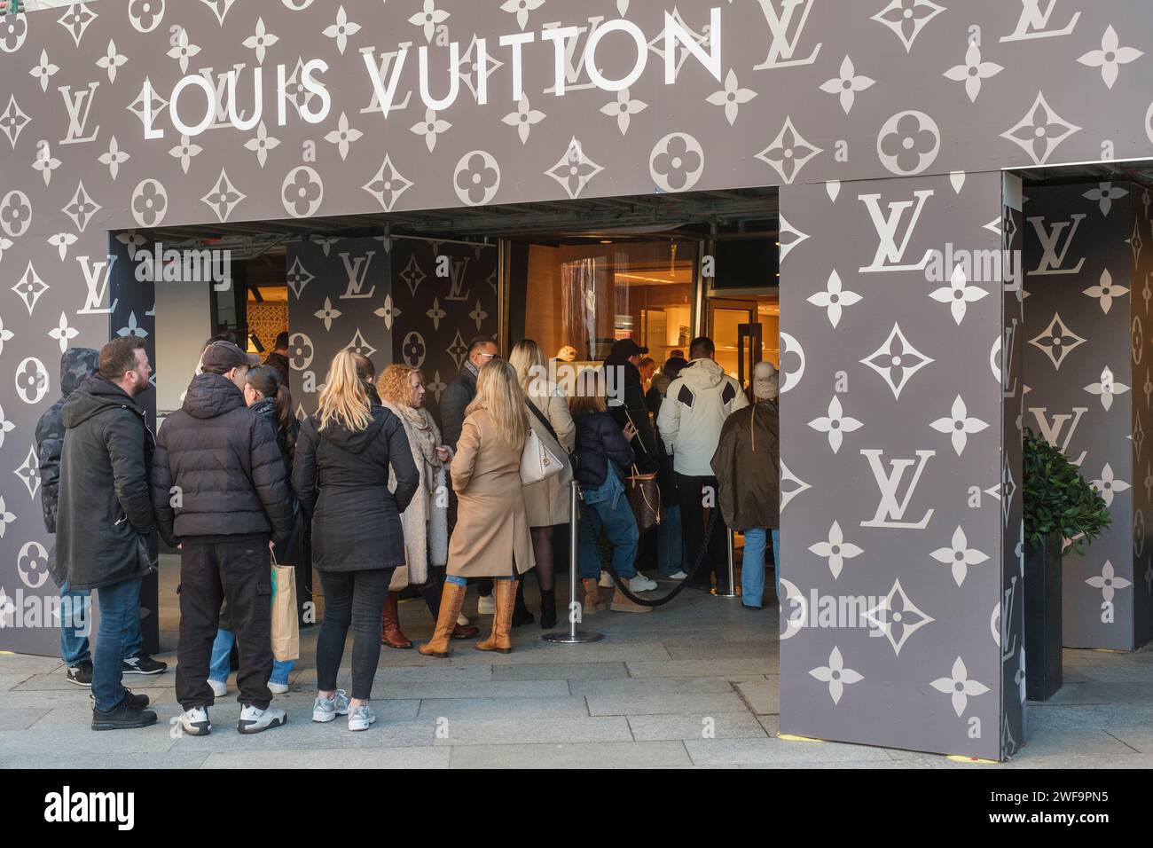 Queue of people waiting in front of the Cologne branch of the Parisian ...