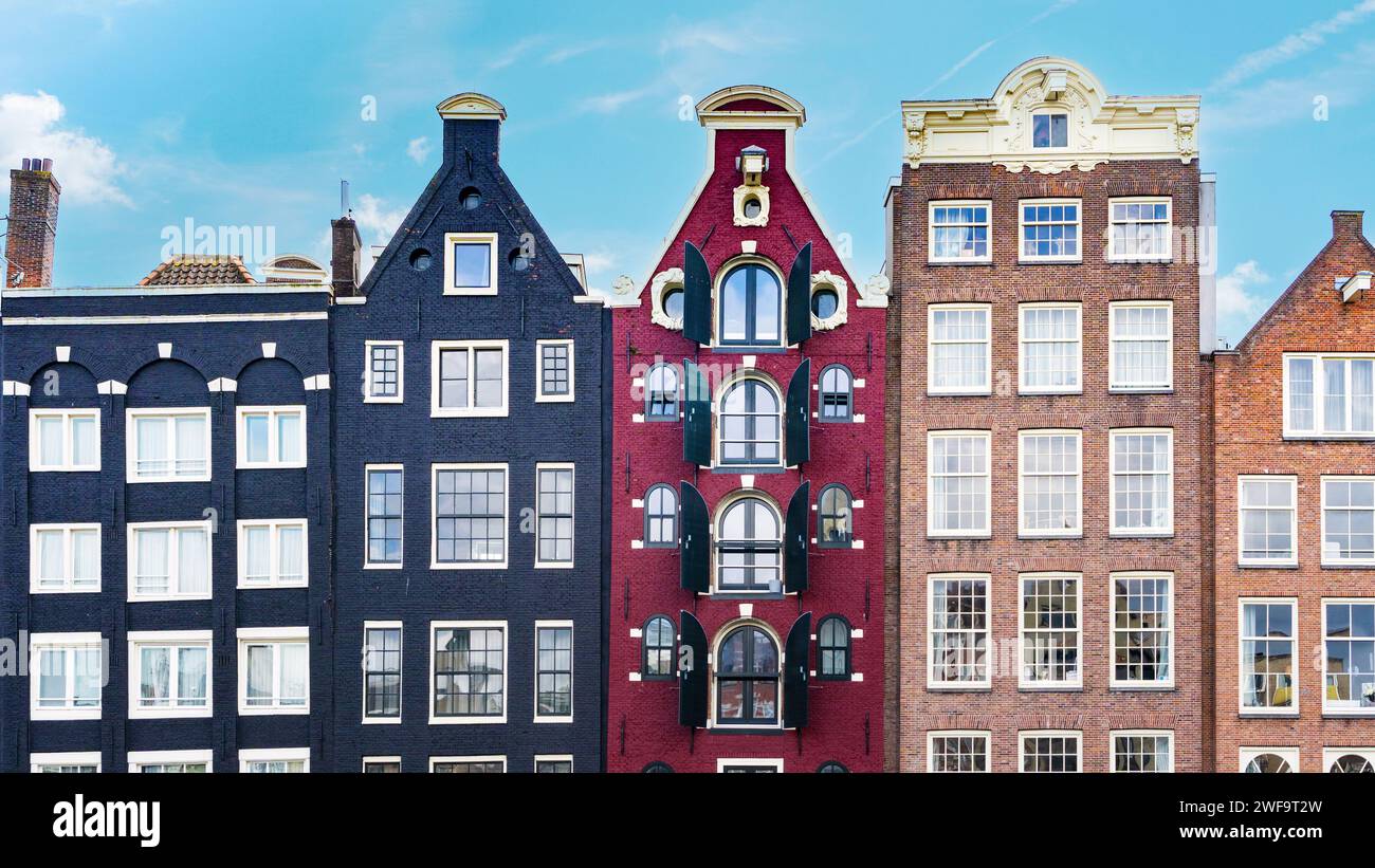 Dancing houses of Amsterdam close-up against the blue sky. Damrak Canal ...