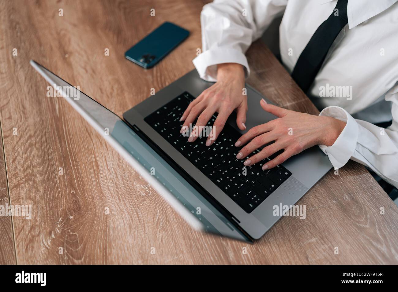 Top view of unrecognizable businesswoman using computer, typing keyboard, analyzing digital data ...
