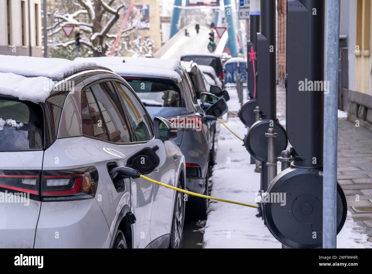 Winter in the city, electric cars charging at charging stations in the ...