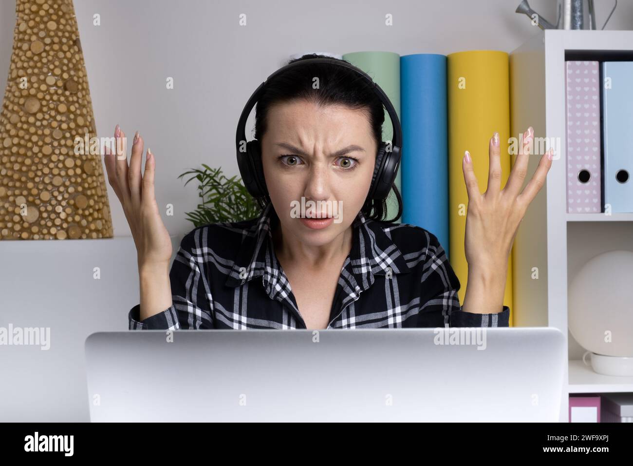 A surprised woman in a home office, conversing with a customer using a ...