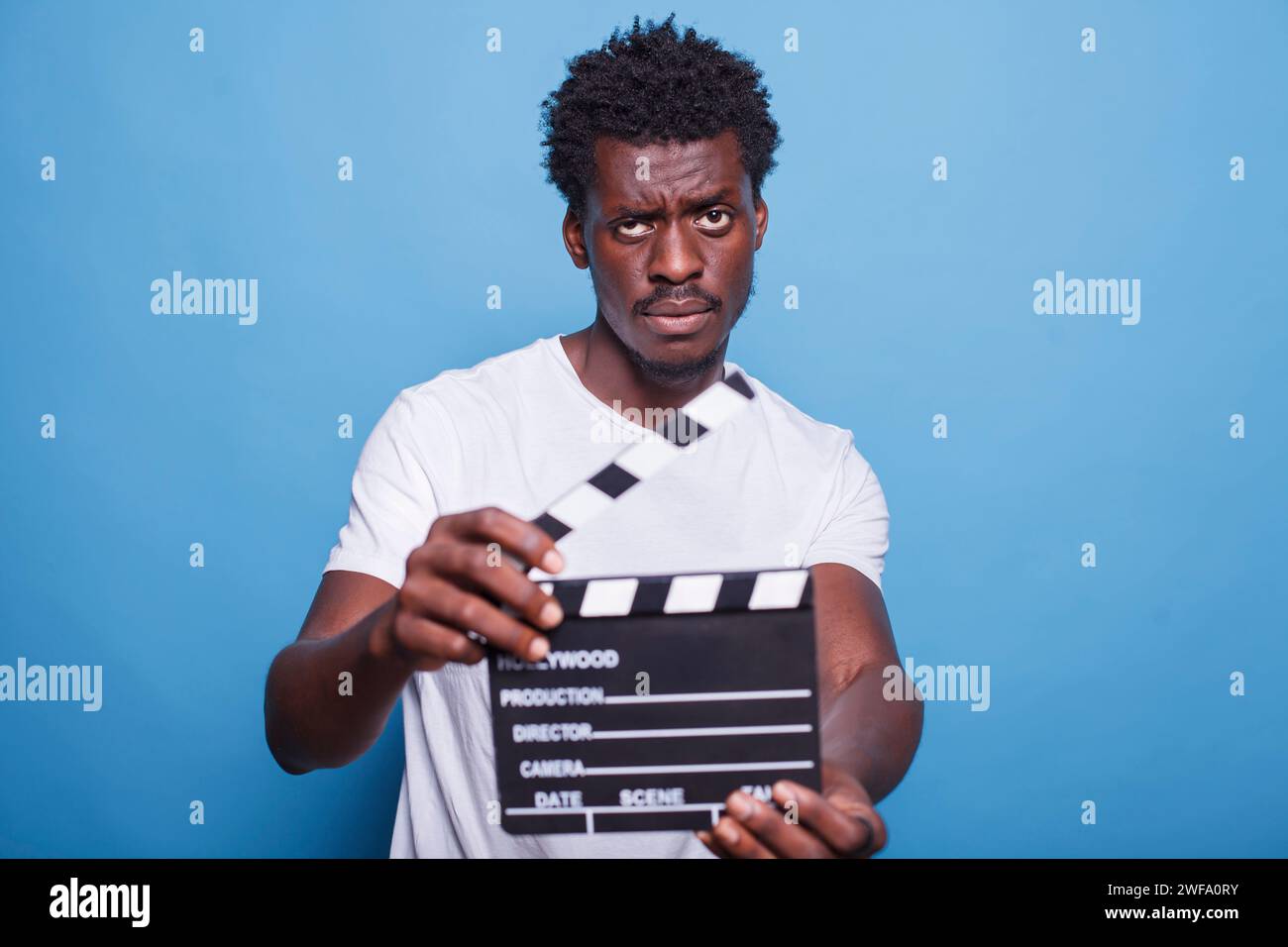 African American producer grasping a clapperboard used for cutting ...