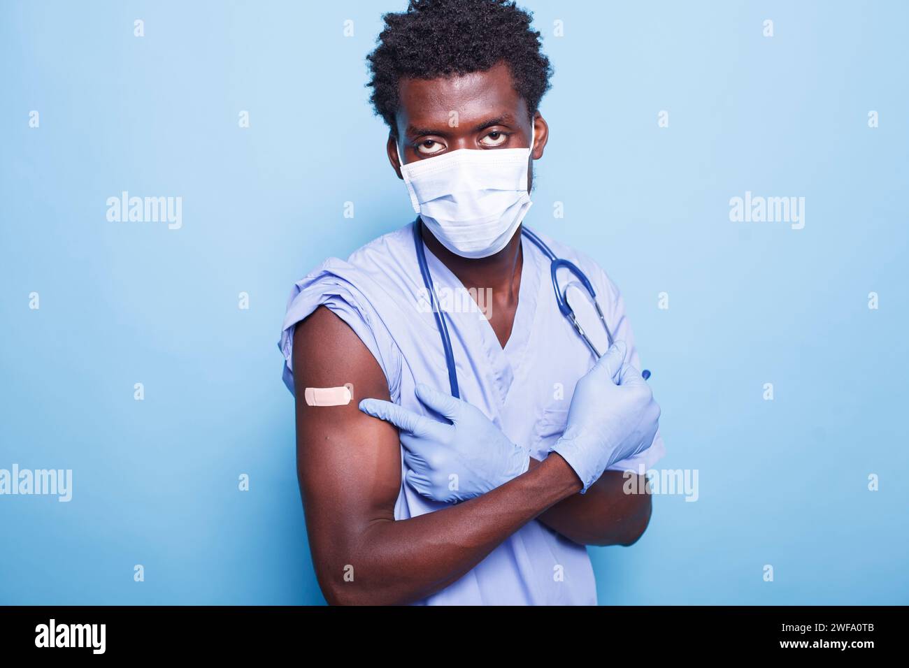 African American nurse with face mask pointing to vaccination injection ...
