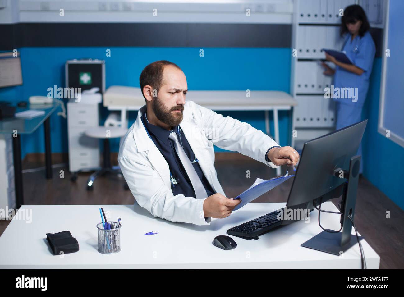 Image shows a committed male doctor reviewing and analyzing his notes ...