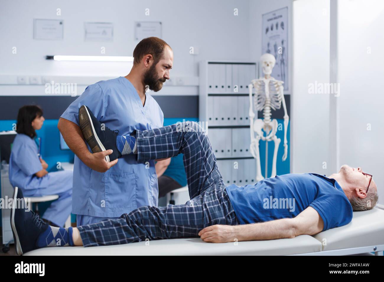 Orthopedic nurse assists senior patient recovering from knee injury at ...