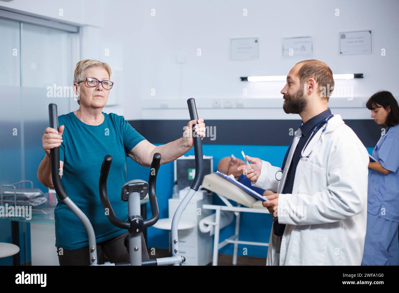 Male doctor talking to senior patient doing physical activity to ...