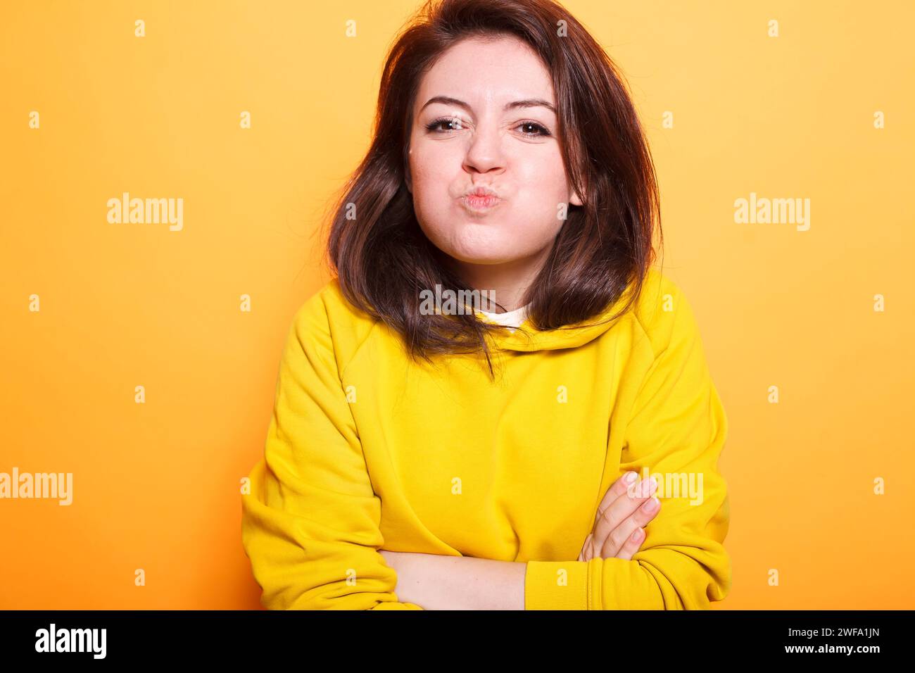 Confident beauty model with brunette hair makes a kissy face on camera ...