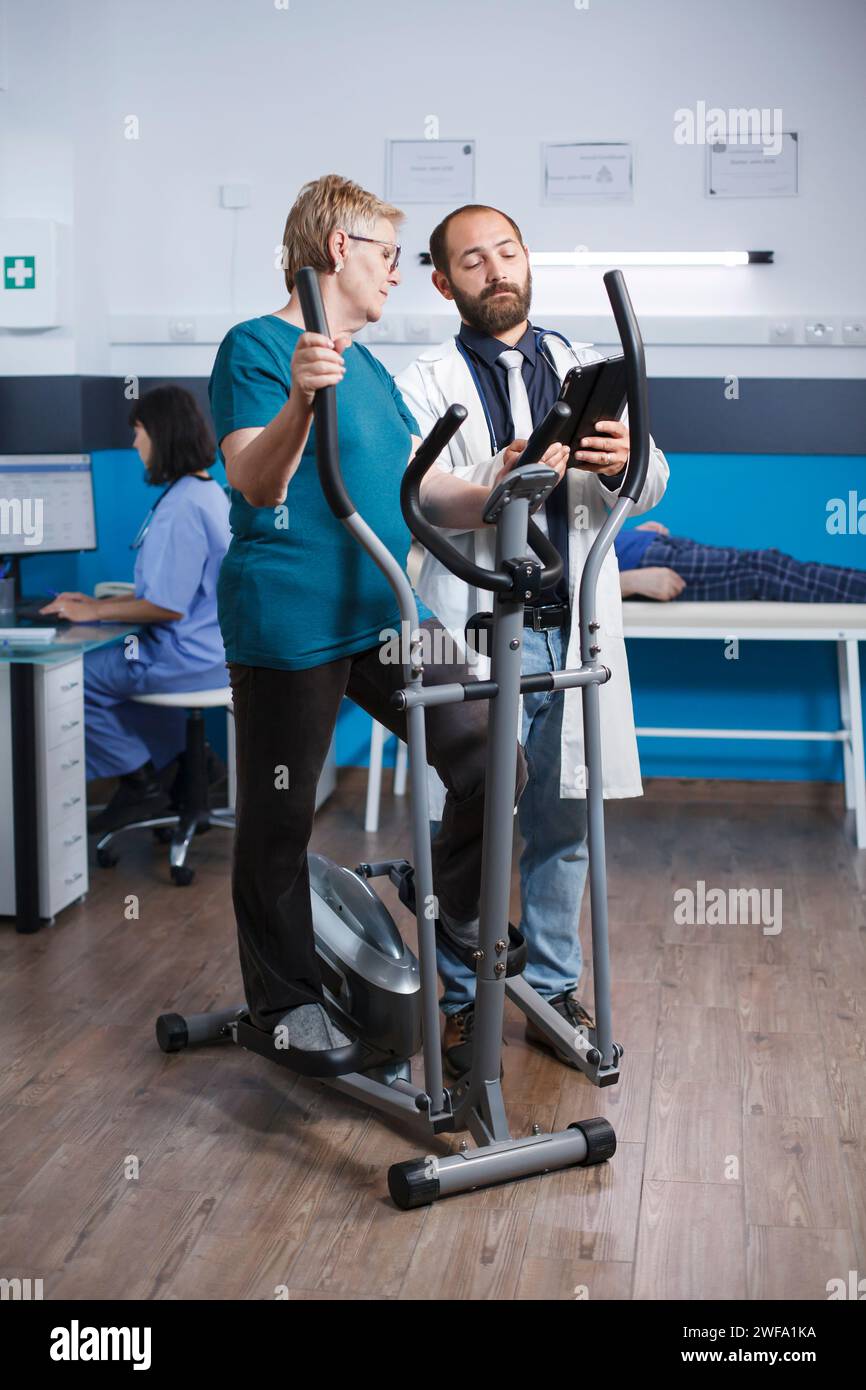 Male doctor holding digital tablet for checkup with old woman at ...