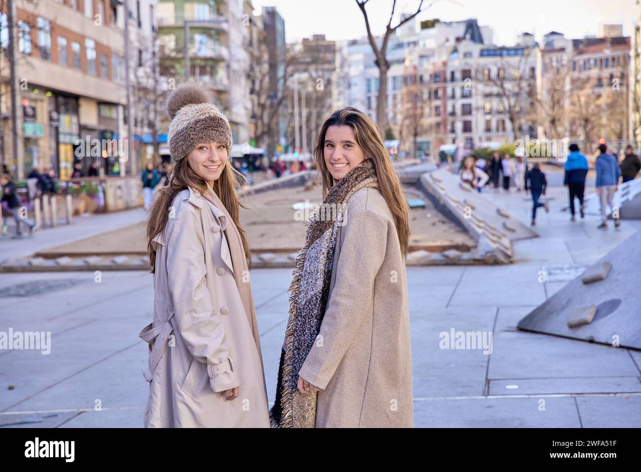 Back view of two friends walking together looking back Stock Photo - Alamy