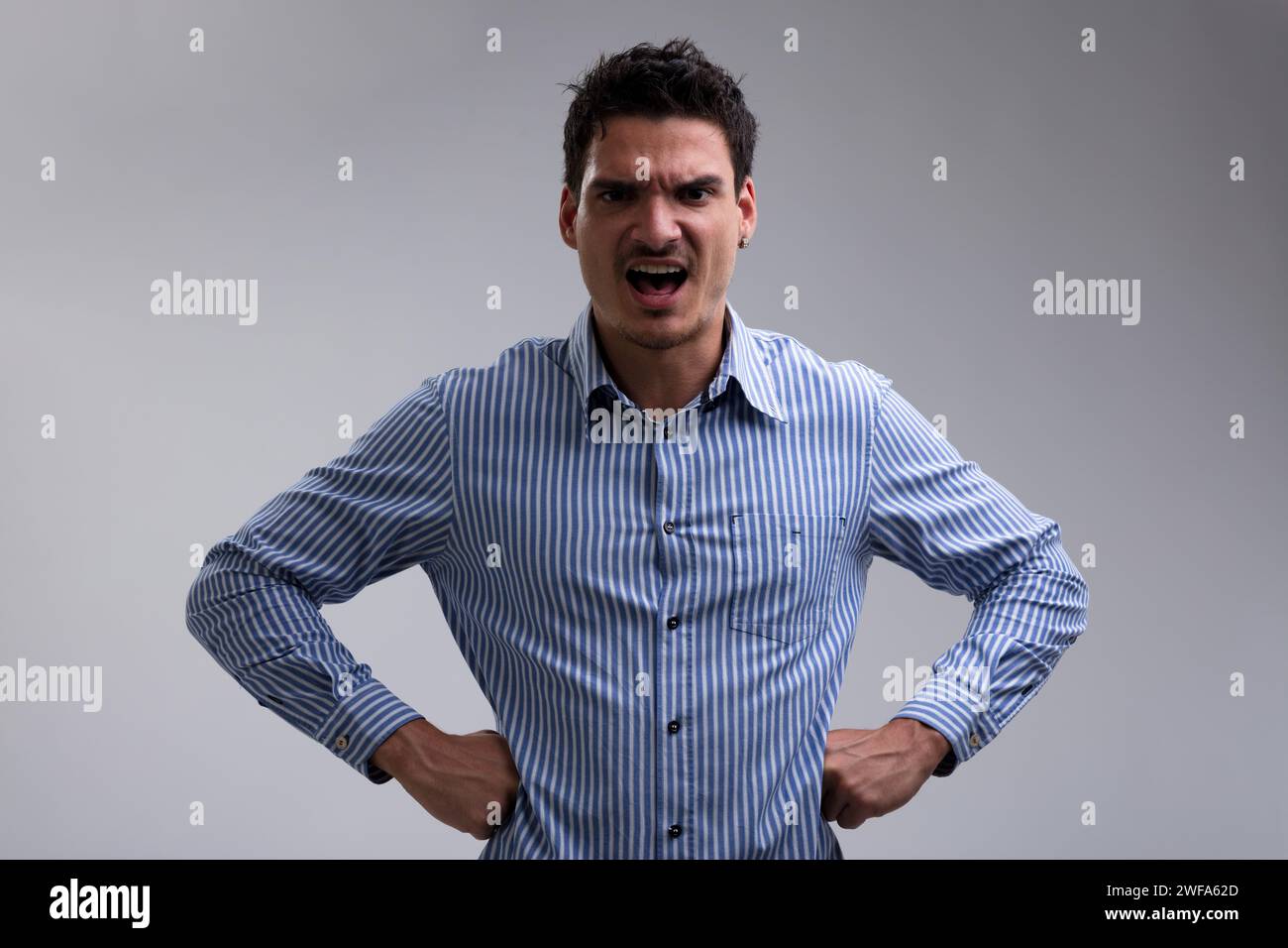 Man in blue and white striped shirt, angrily gestures at you, signaling ...