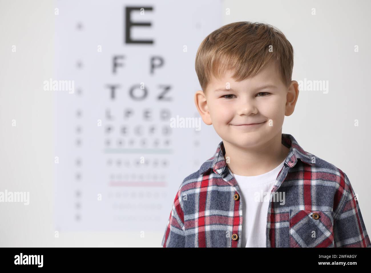 Cute little boy against vision test chart Stock Photo - Alamy