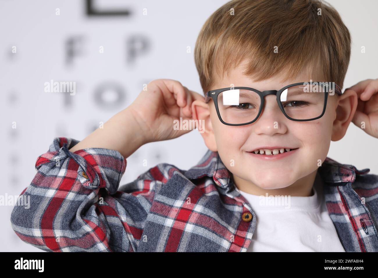 Little boy with glasses against vision test chart Stock Photo - Alamy