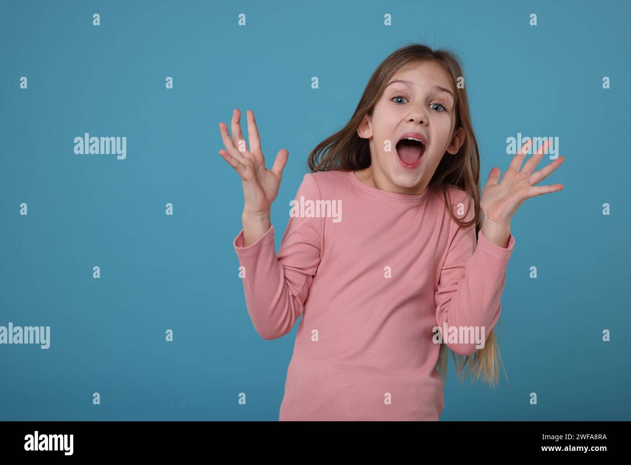 Portrait of surprised girl on light blue background Stock Photo - Alamy