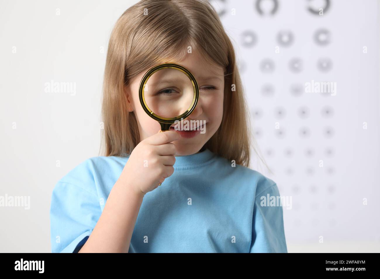 Little girl with magnifying glass against vision test chart Stock Photo ...