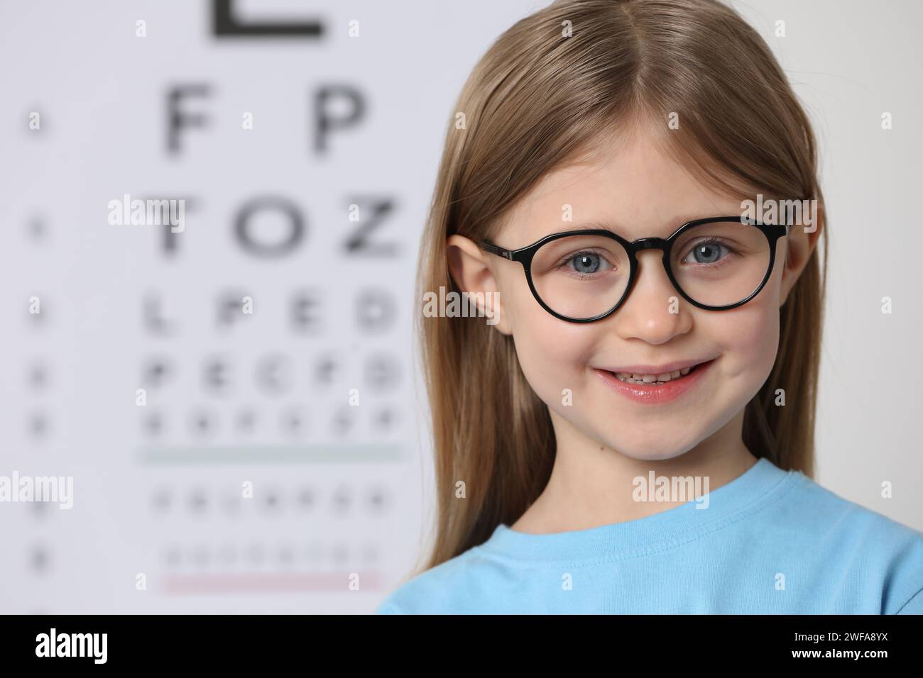 Little girl with glasses against vision test chart Stock Photo - Alamy