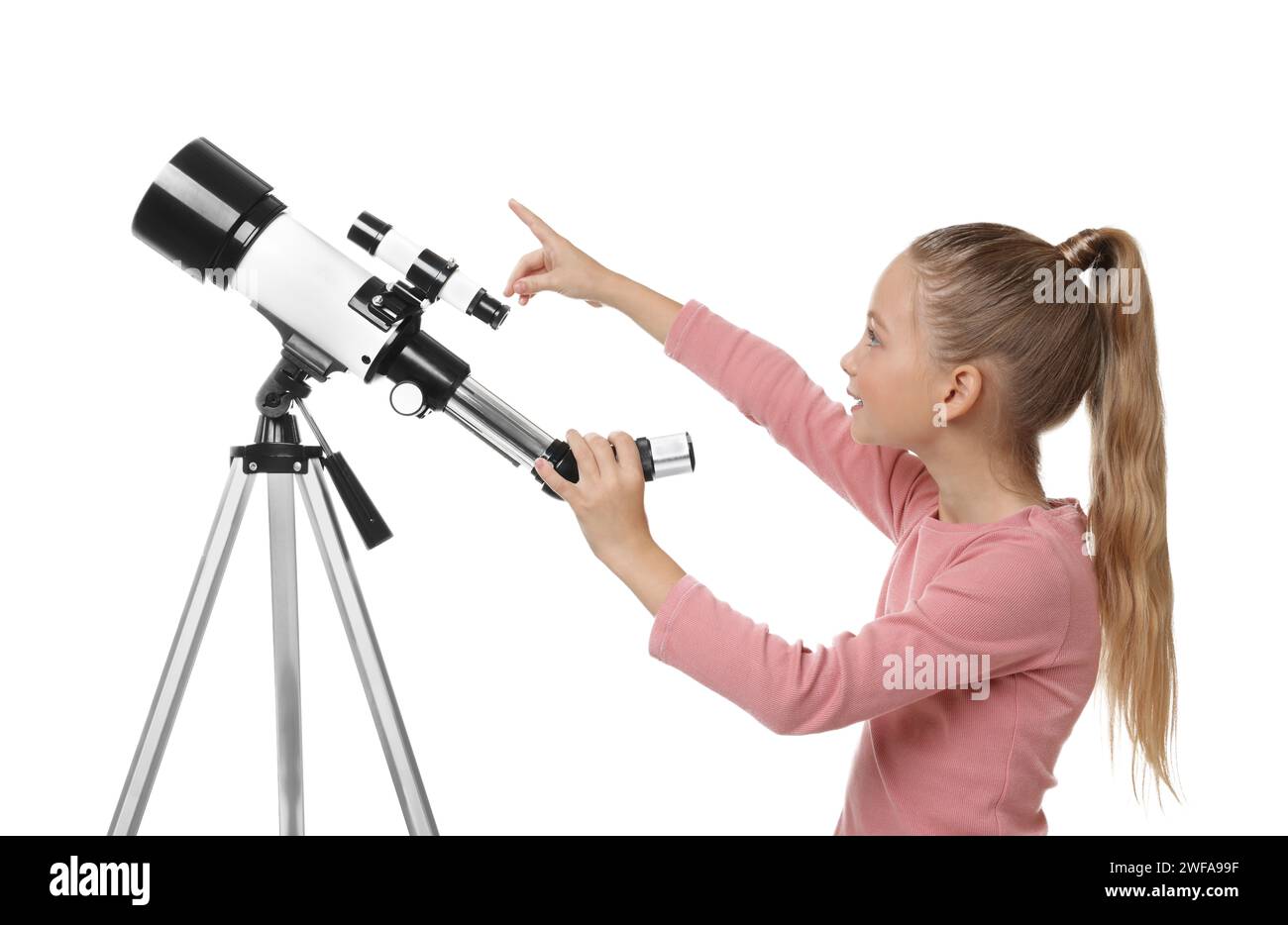 Happy little girl with telescope pointing at something on white ...