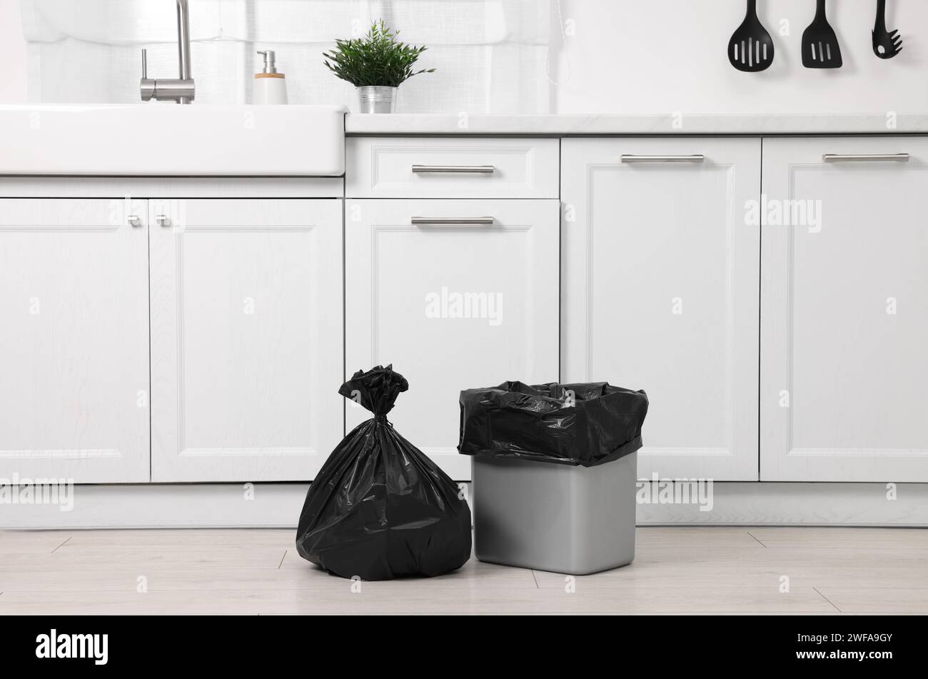 Plastic garbage bag and trash can in kitchen Stock Photo - Alamy