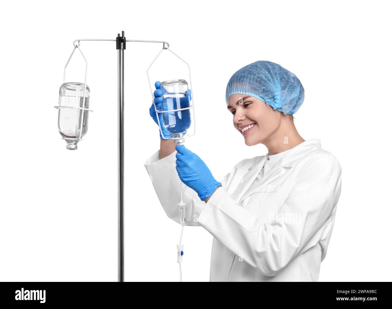 Nurse setting up IV drip on white background Stock Photo - Alamy