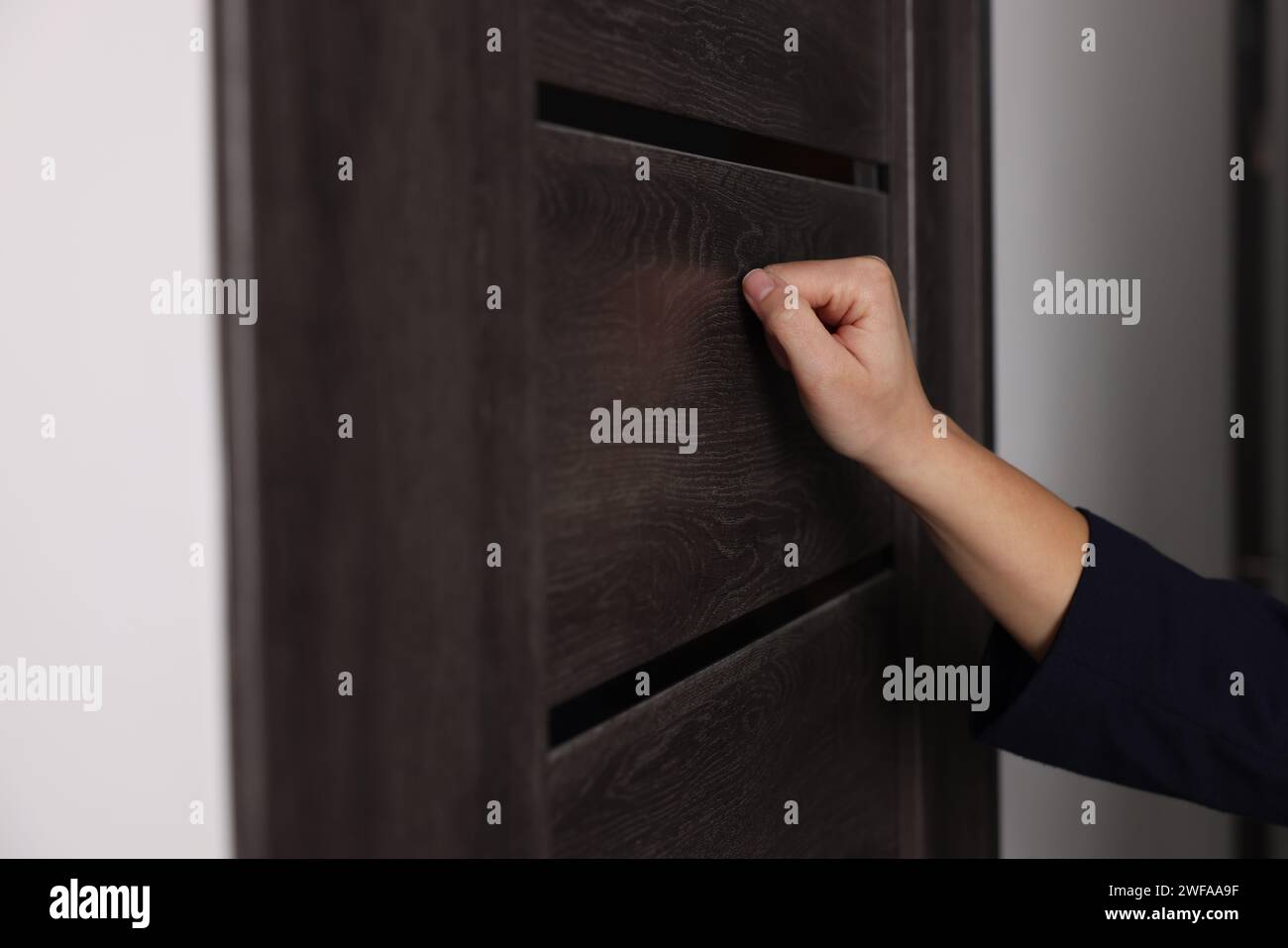 Collector knocking on door indoors, closeup view Stock Photo - Alamy