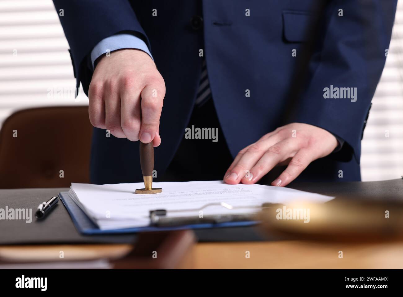 Notary stamping document at table in office, closeup Stock Photo - Alamy