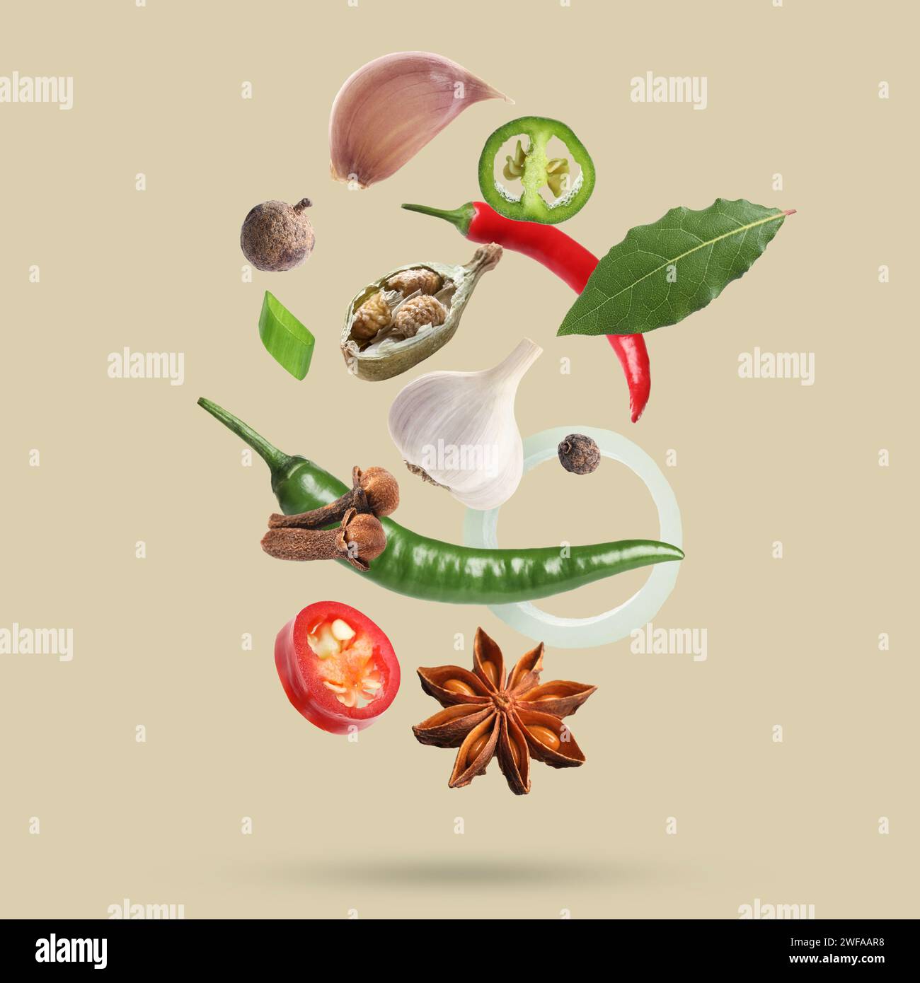 Different spices falling on dark beige background Stock Photo - Alamy