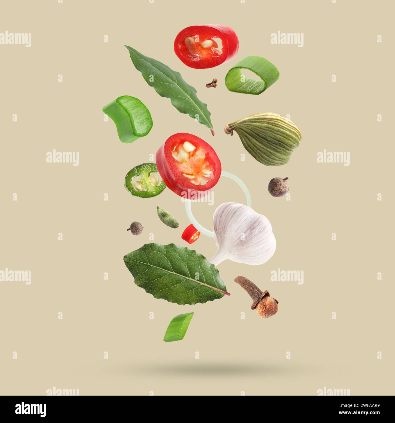 Different spices falling on dark beige background Stock Photo - Alamy