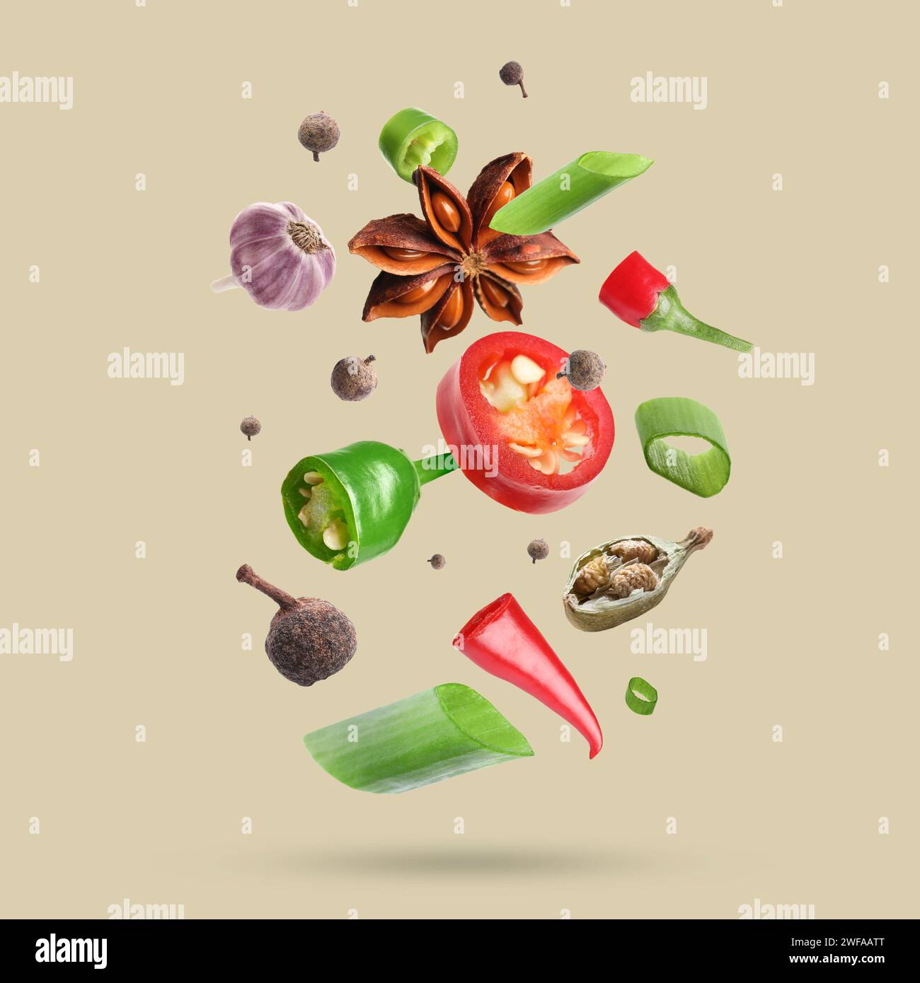 Different spices falling on dark beige background Stock Photo - Alamy