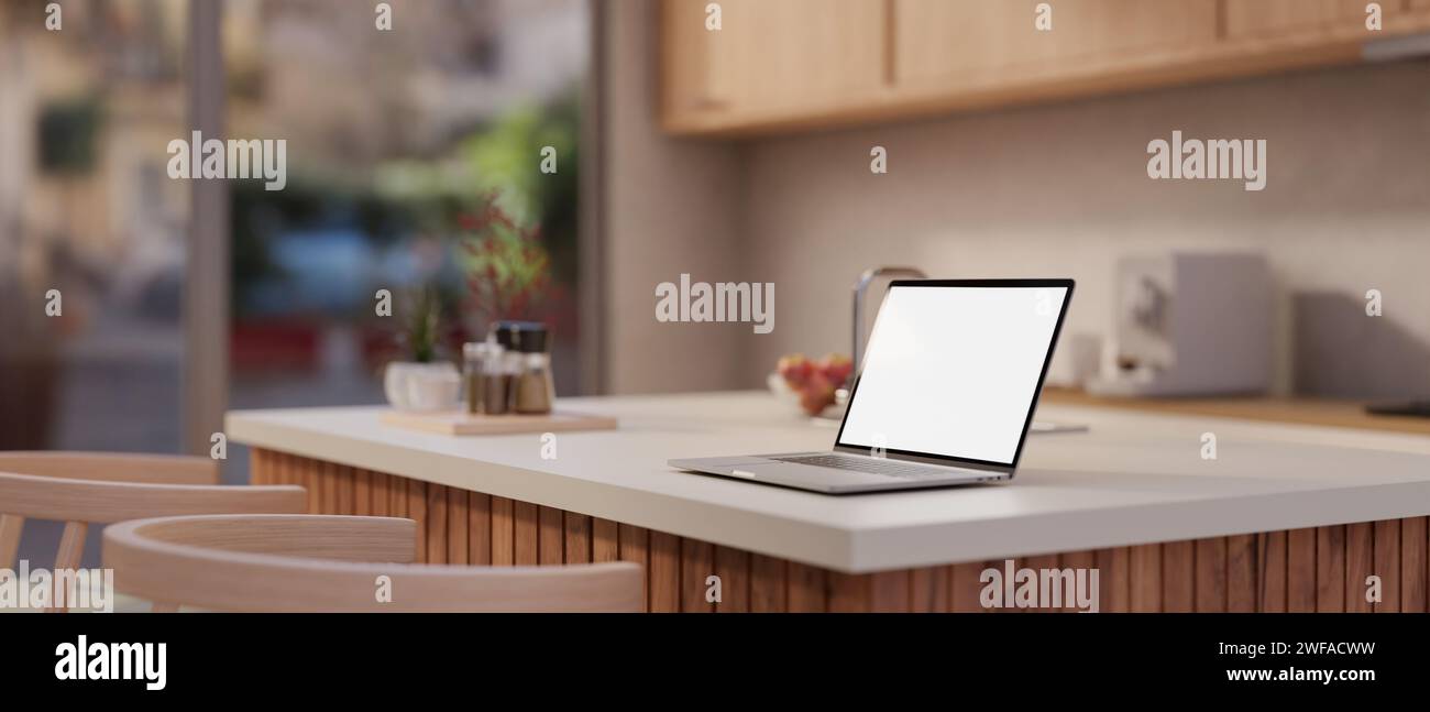 A side-view image of a white-screen laptop computer on a kitchen island ...