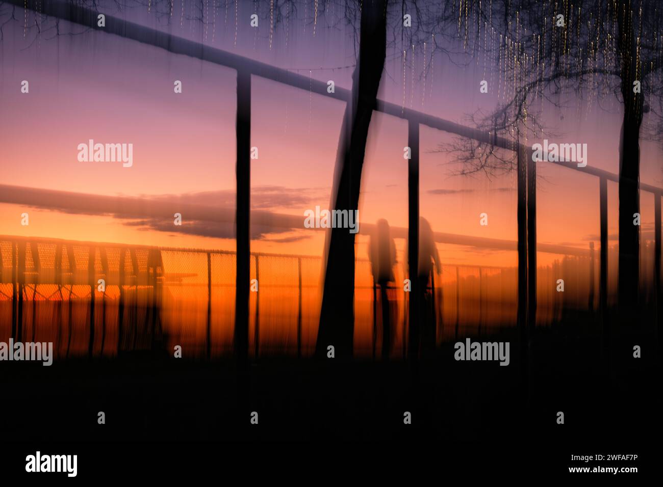 Two people walk on White Rock's promenade during a spectacular sunset ...