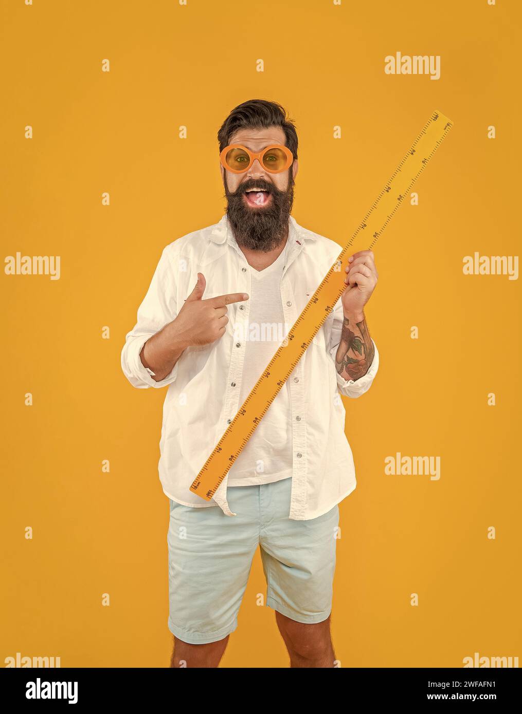 photo of man hold measuring ruler, point finger isolated on yellow in ...